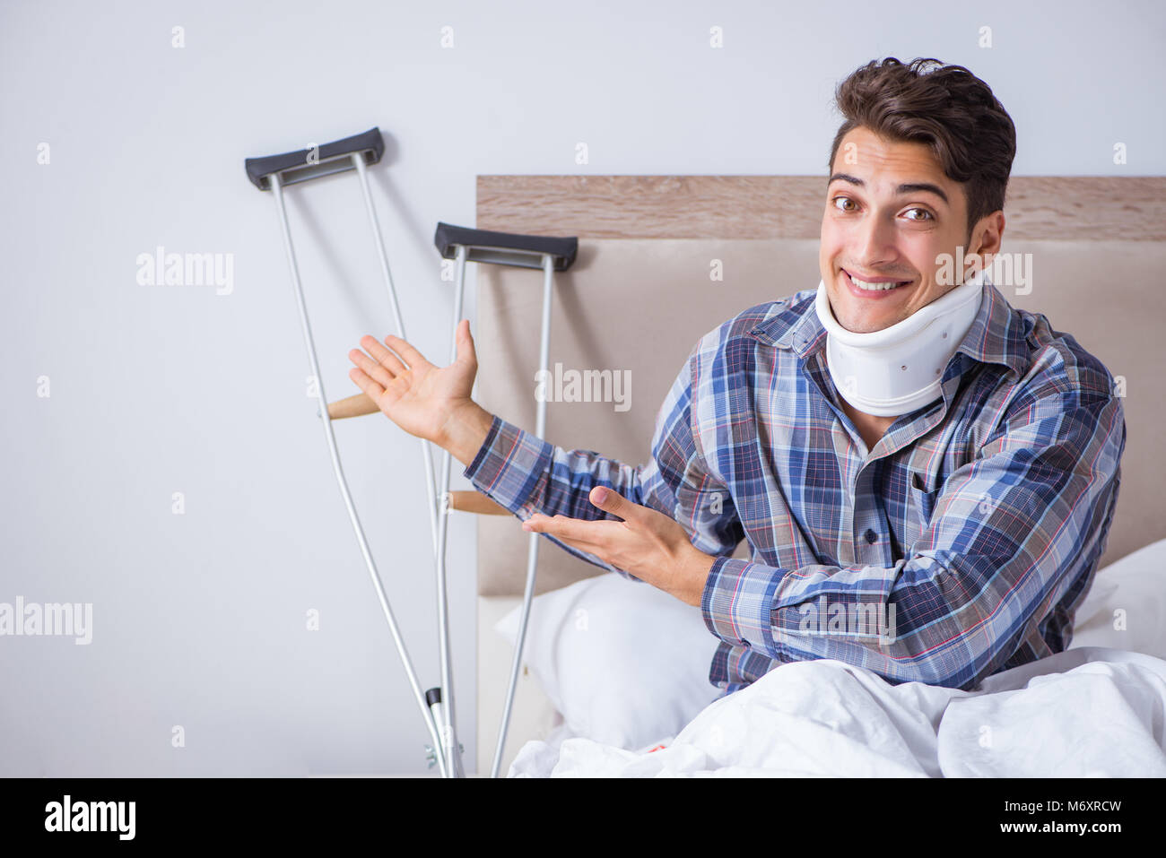 Injured man in bed at home with crutches hi-res stock photography and ...