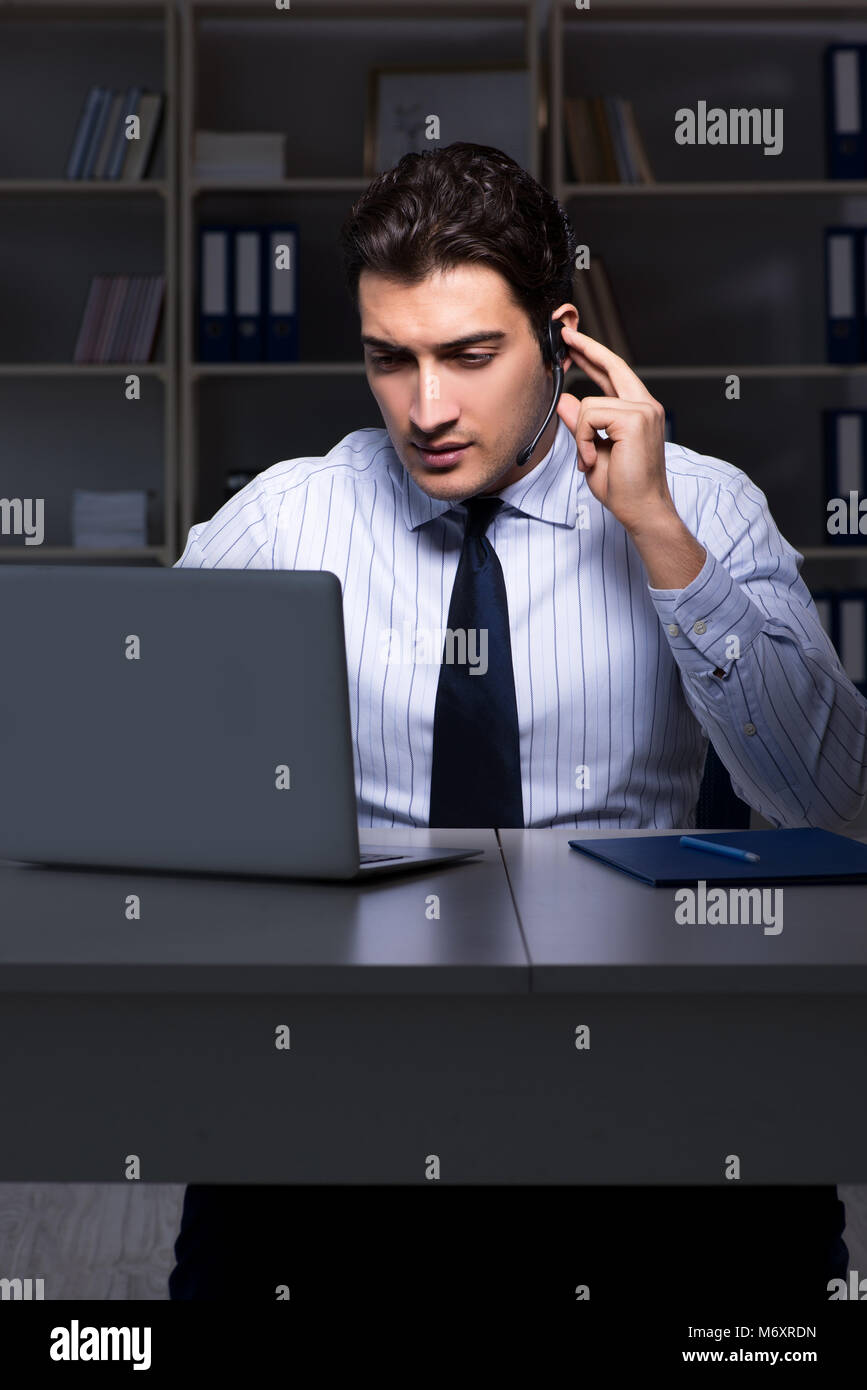 Call center operator talking to customer during night shift Stock Photo ...