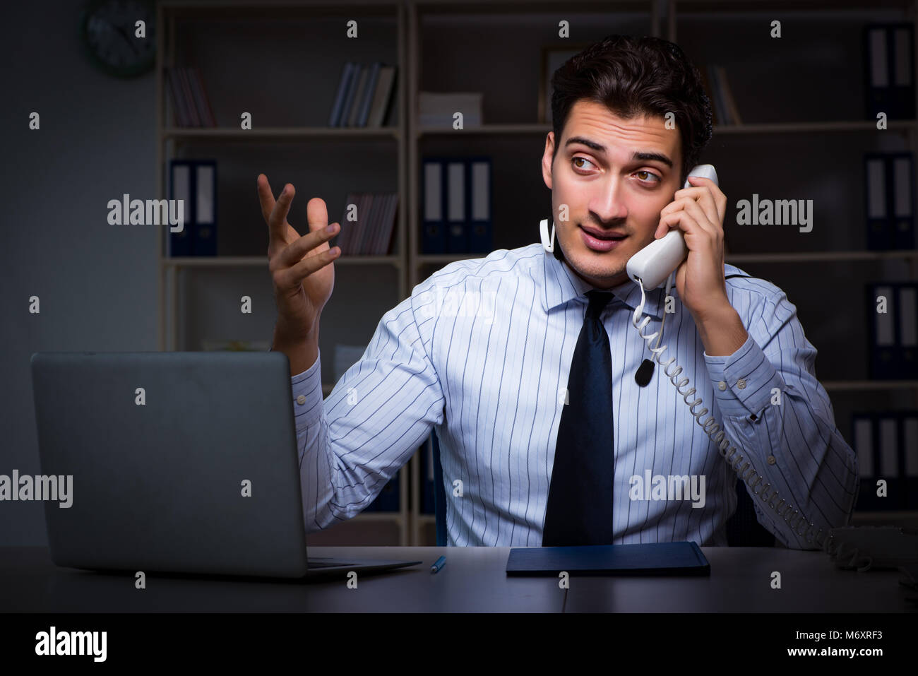 Call center operator talking to customer during night shift Stock Photo ...