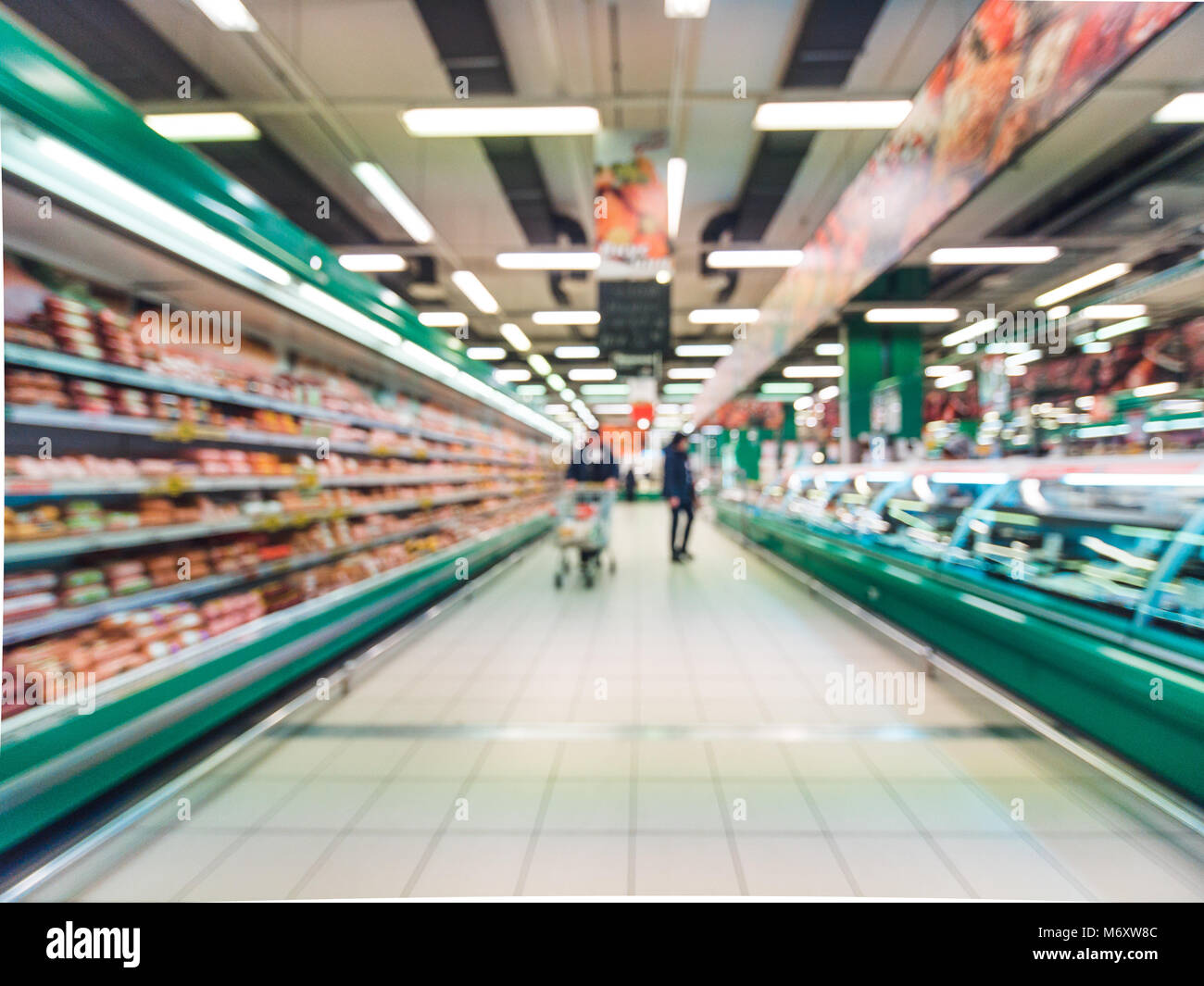 Abstract blurred supermarket aisle with colorful shelves and ...