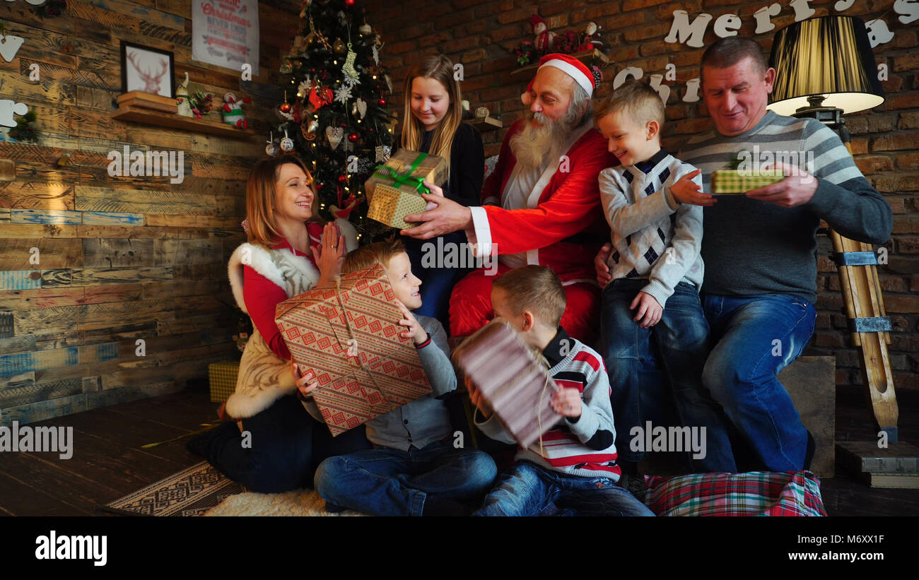 Santa gives presents to happy american family Stock Photo - Alamy