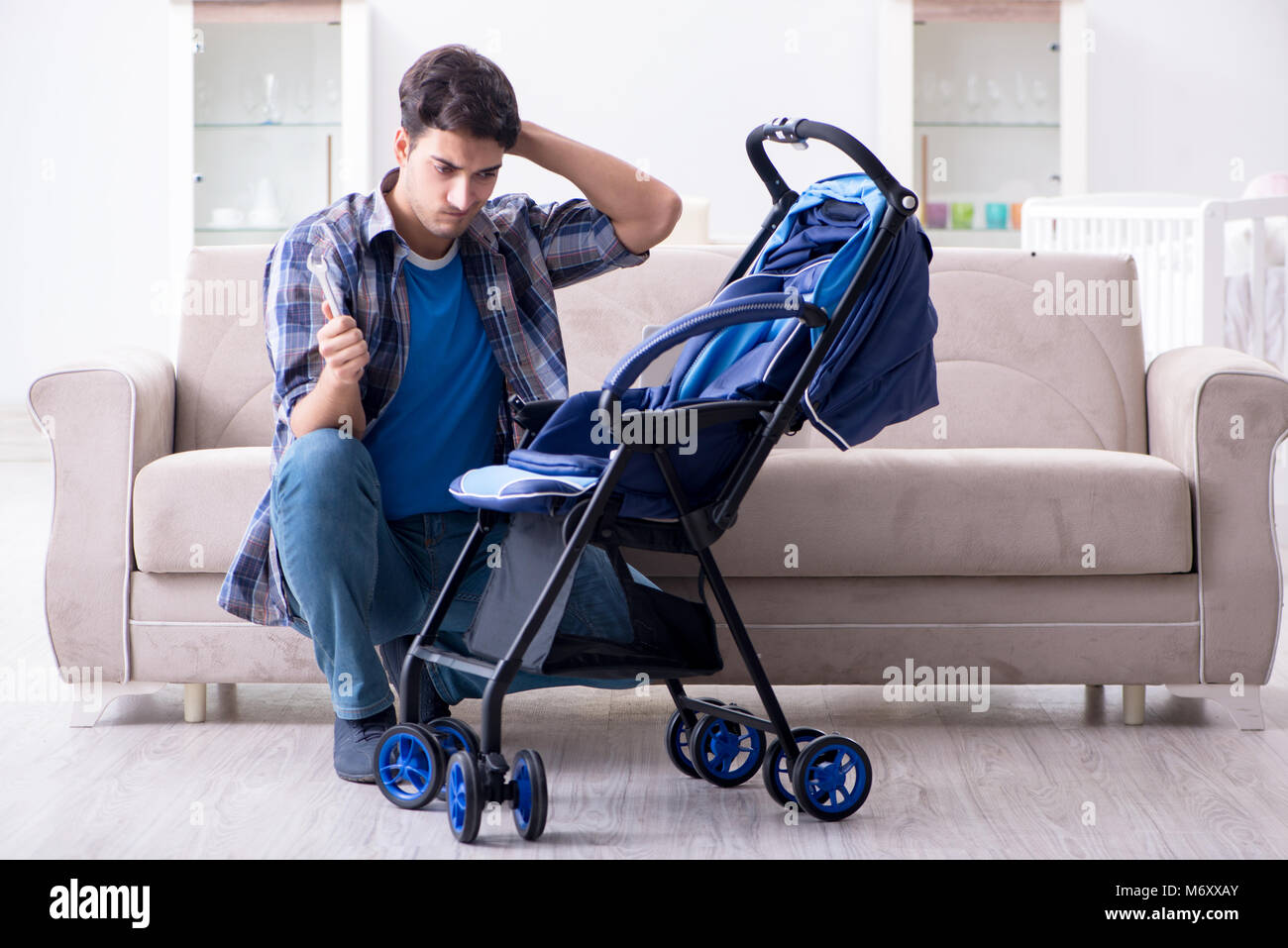 Young father assembling baby pram at home Stock Photo - Alamy