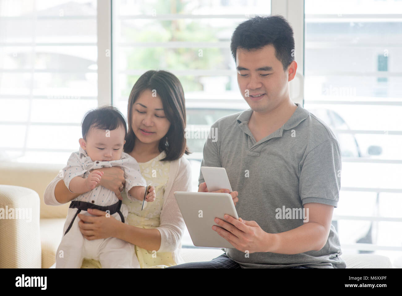 Chinese people scanning QR code with smart phone. Asian family at home ...