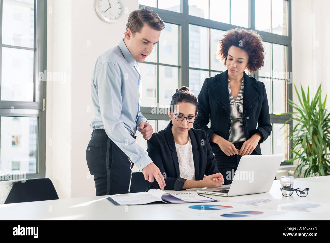 Three young colleagues talking during break in the meeting room Stock ...