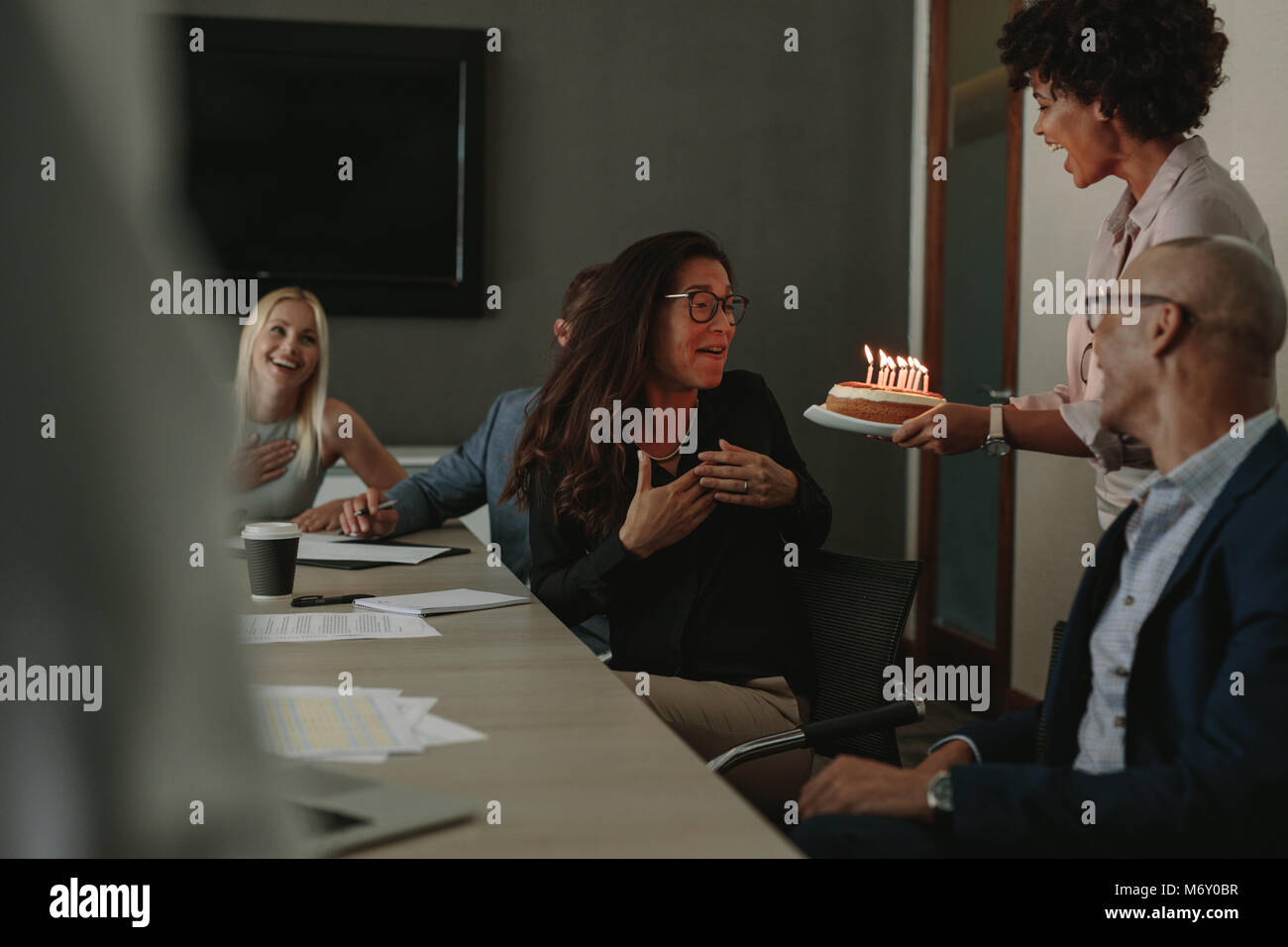 Office workers celebrating birthday of cheerful female colleague with ...