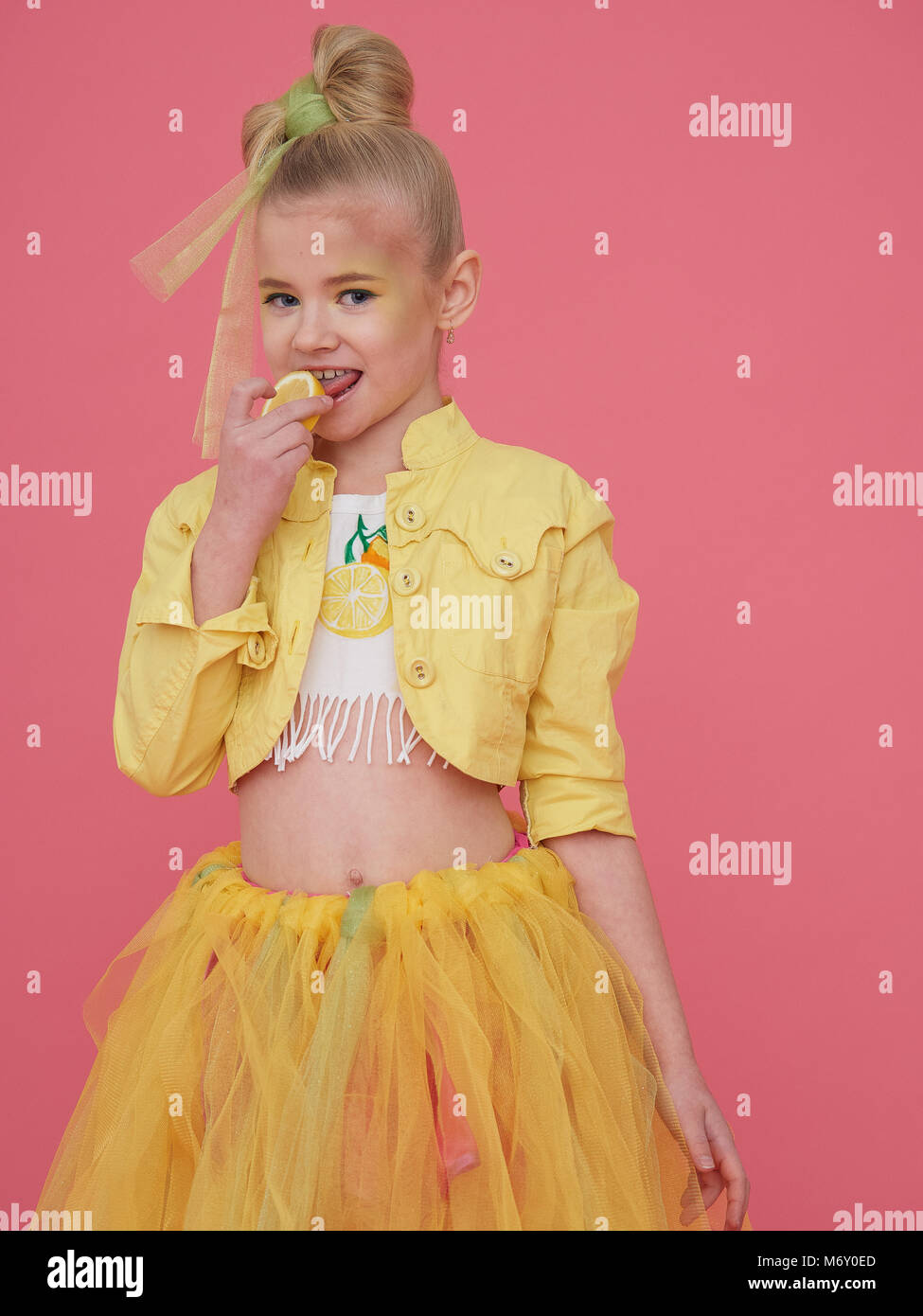 A small child changed into a suit of bright yellow lemon. On the girl's ...