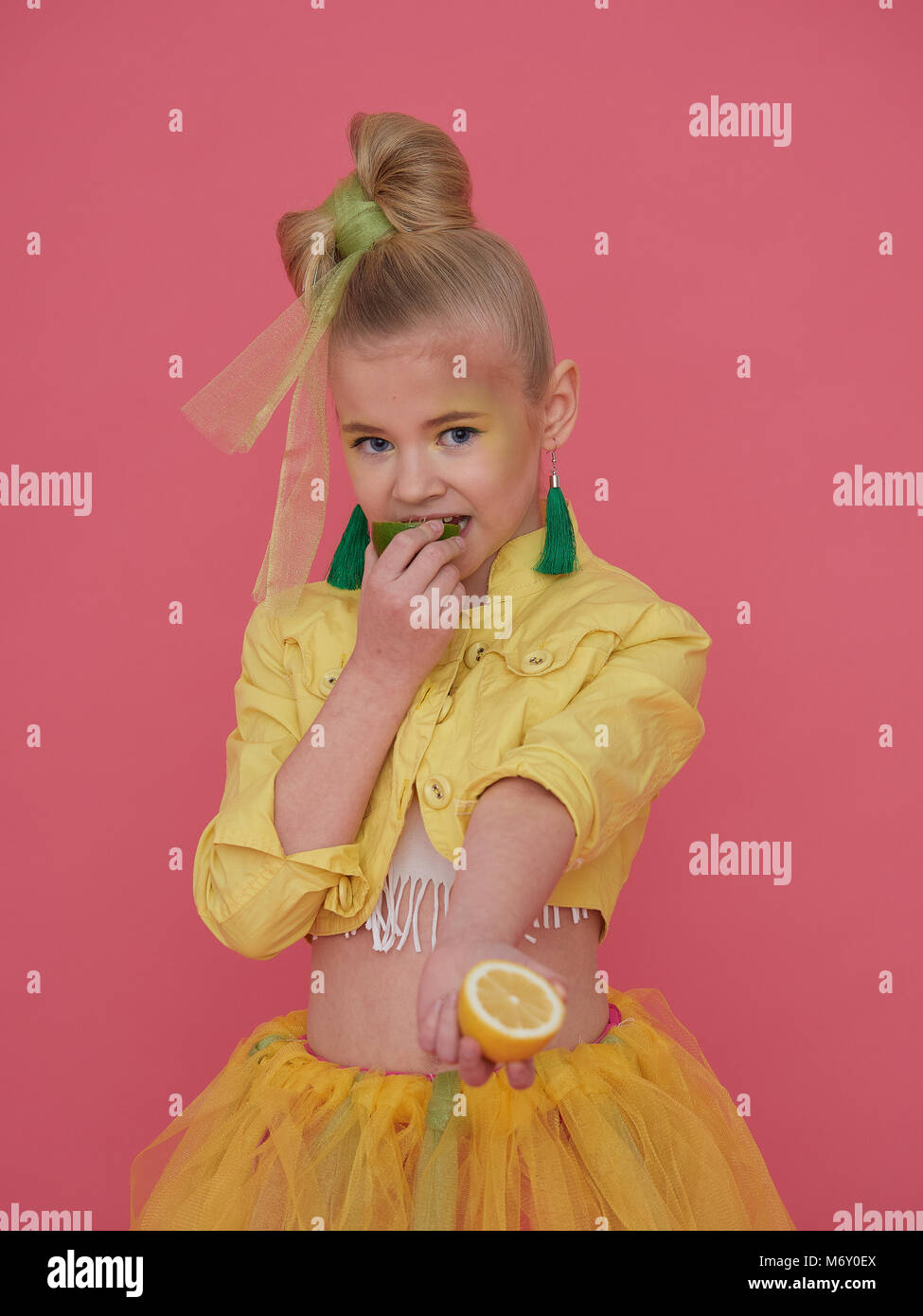 A small child changed into a suit of bright yellow lemon. On the girl's ...