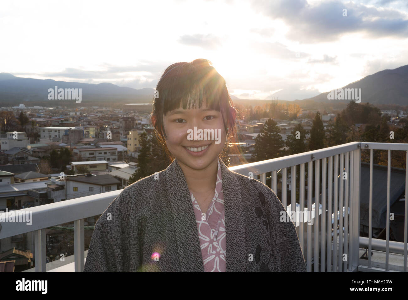 Beautiful girl in a yukata with the view of Mount Fuji during sunset ...