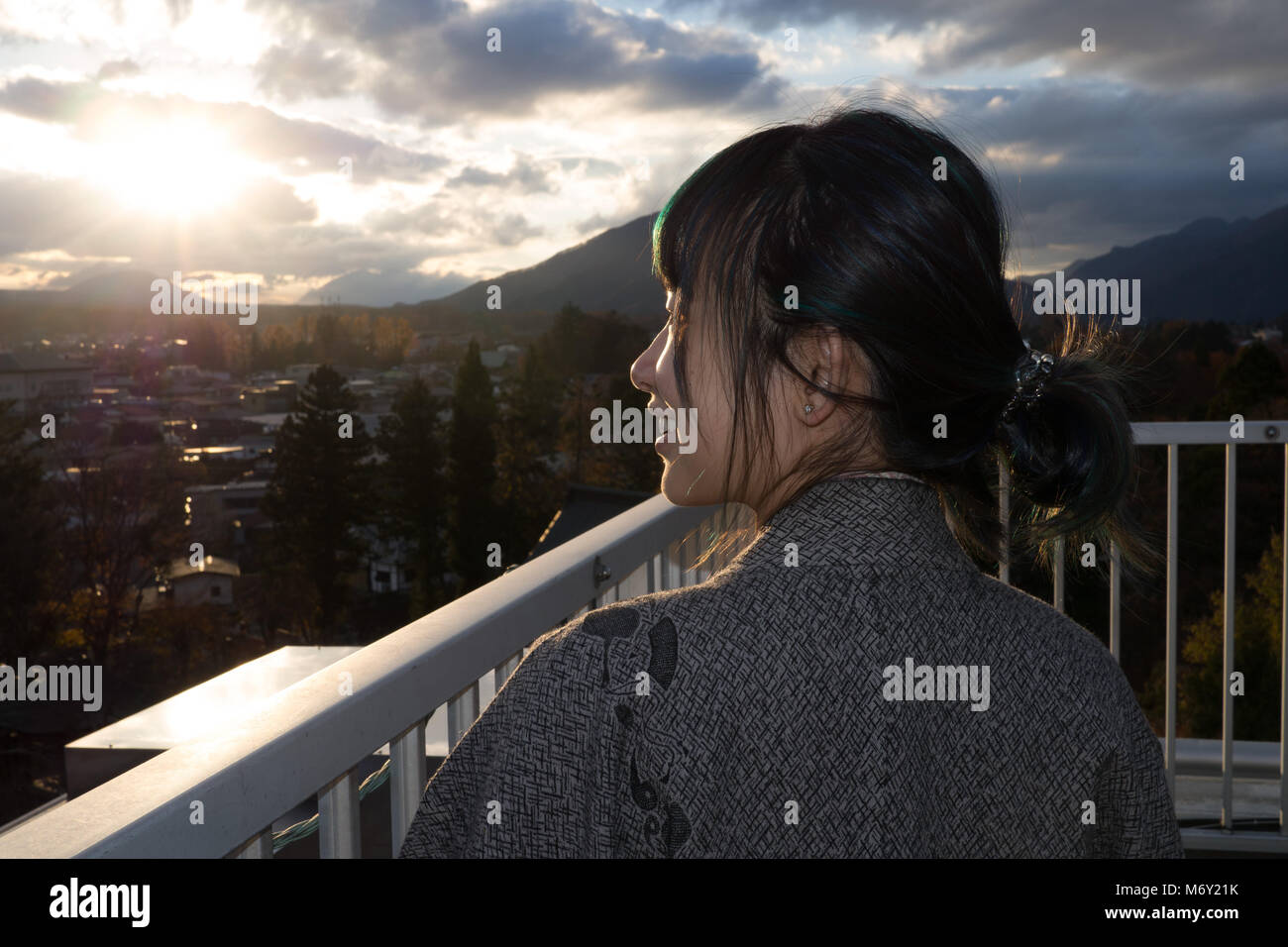 Beautiful girl in a yukata with the view of Mount Fuji during sunset ...