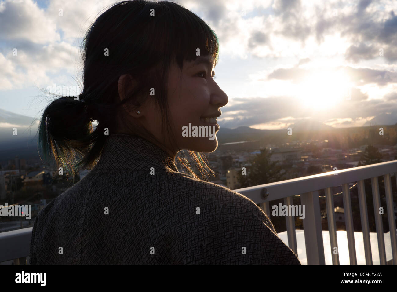 Beautiful girl in a yukata with the view of Mount Fuji during sunset ...
