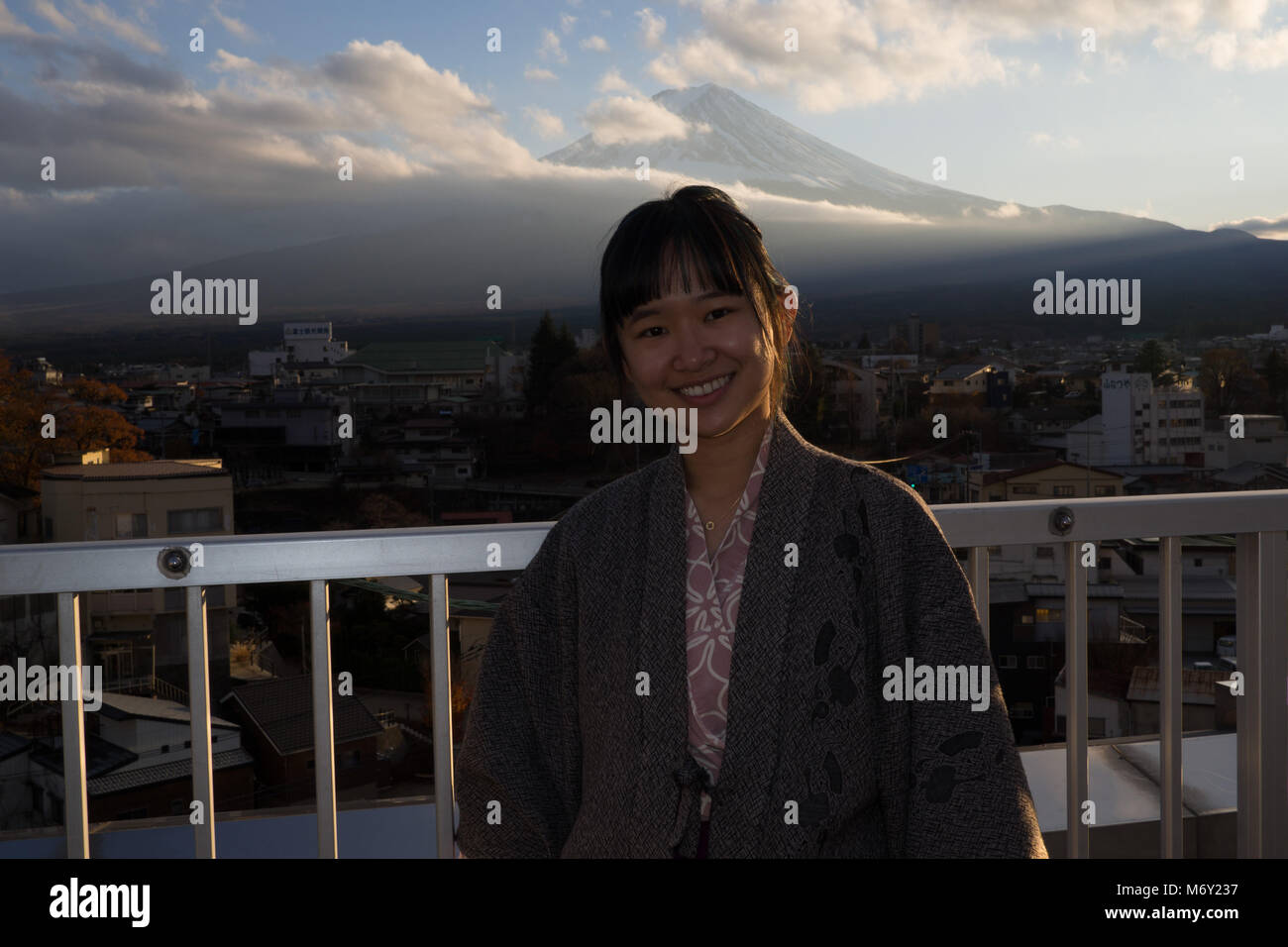 Beautiful girl in a yukata with the view of Mount Fuji during sunset ...