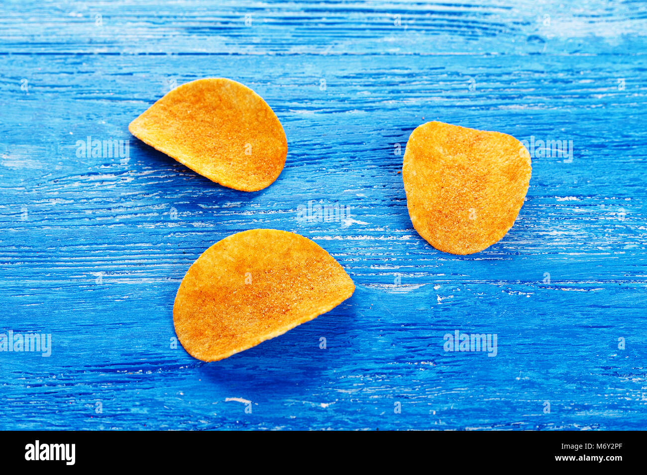 potato chips on a blue wooden background, cold snack, unhealthy eating ...