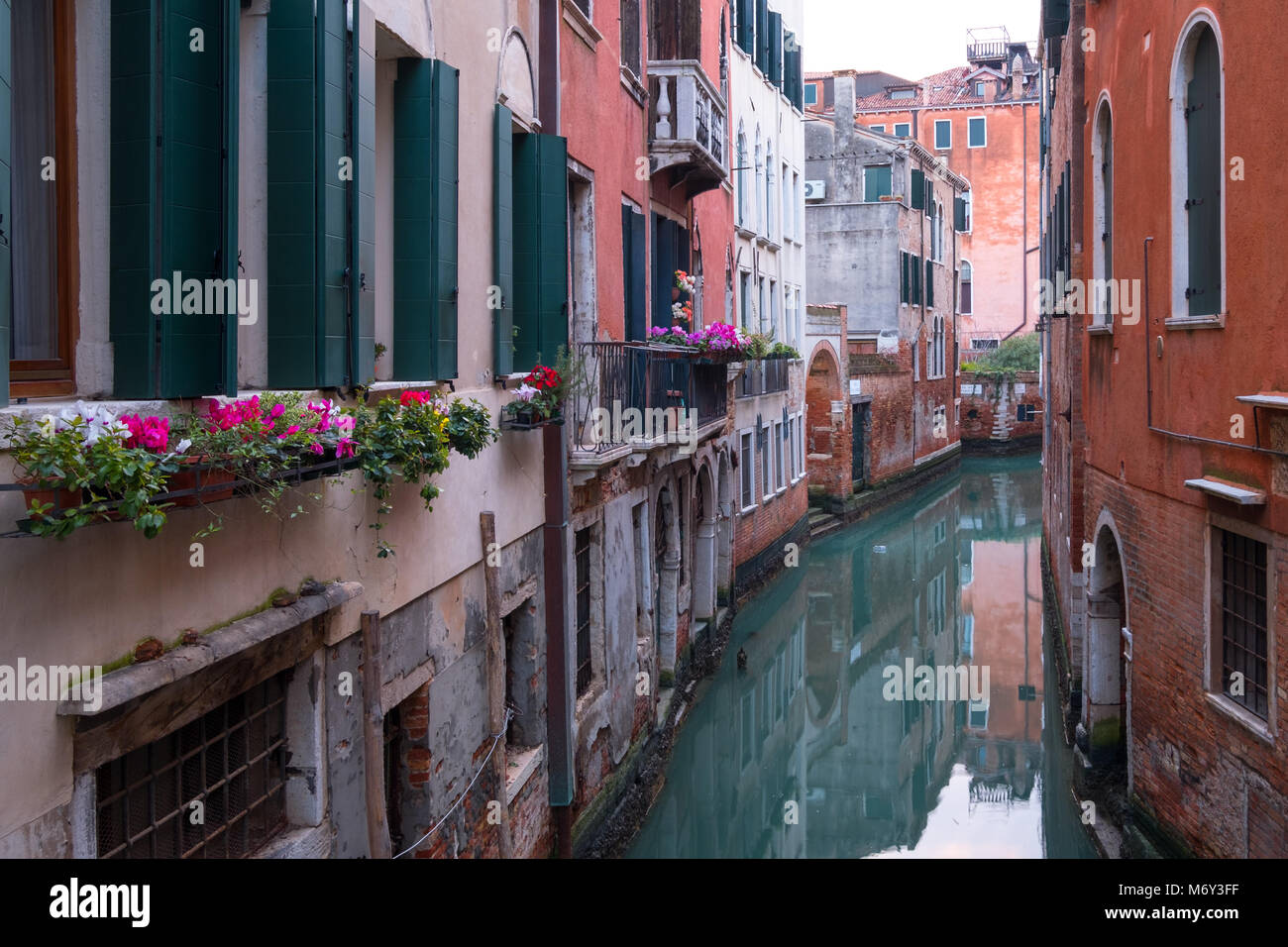 Typical canal scene in Venice showing waterway and buildings reflected ...