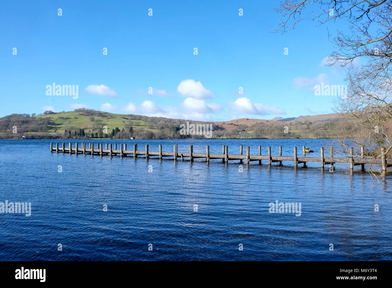 A Long straight beautiful wooden foot jetty jutting out over a calm ...