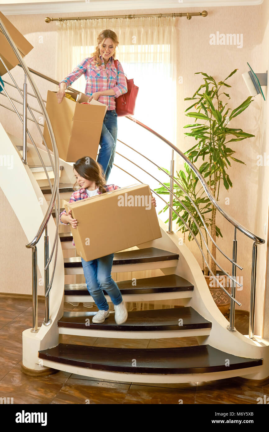 Woman and child carrying boxes Stock Photo - Alamy