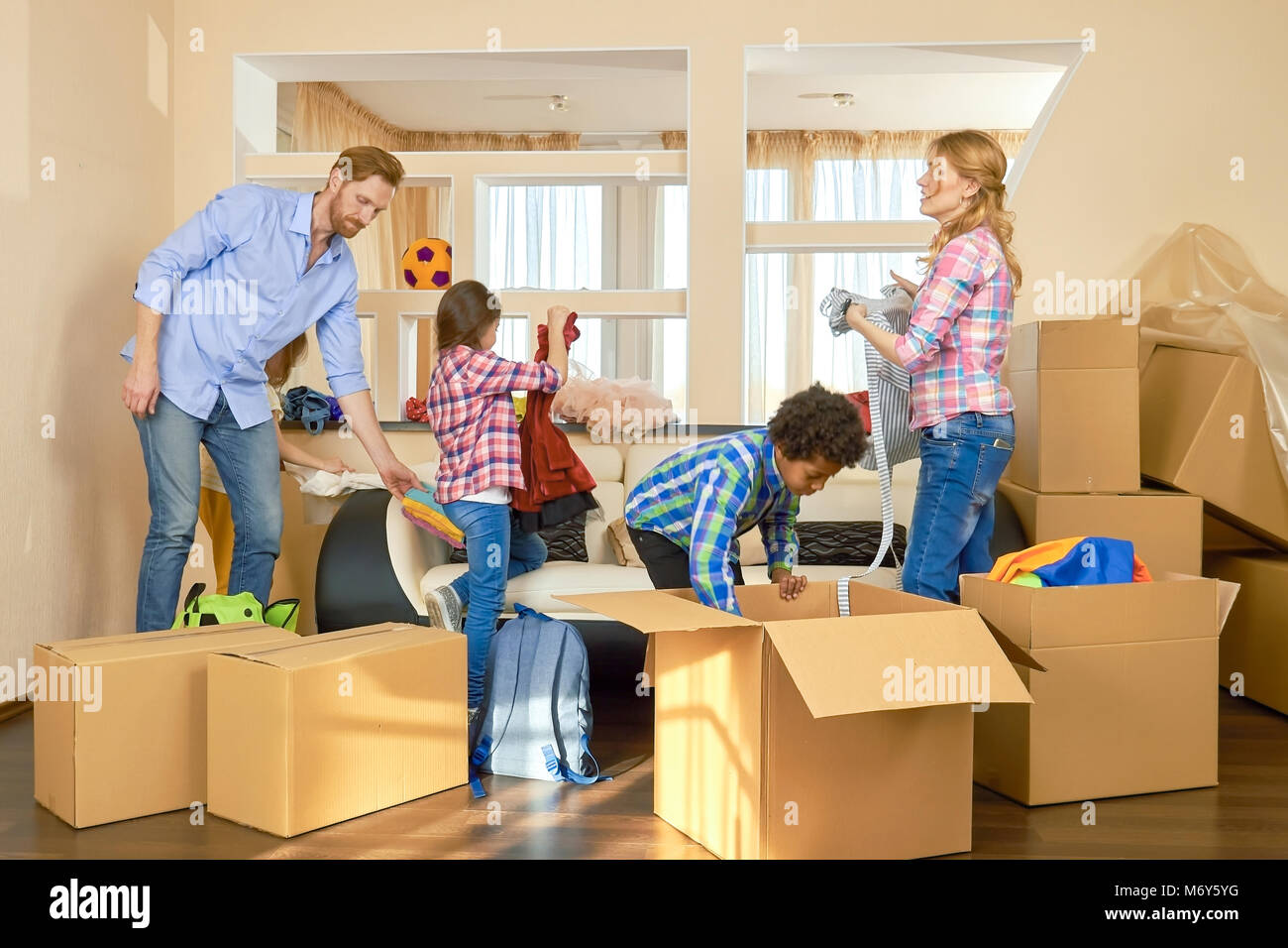 Family unpacking things from boxes Stock Photo - Alamy