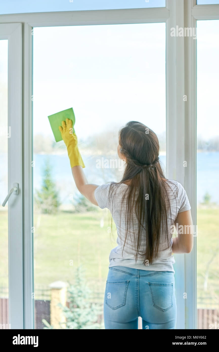 Young female wiping window Stock Photo - Alamy