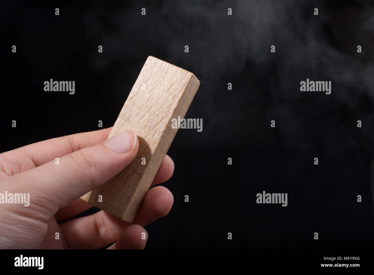 Small piece of cut wood in hand background Stock Photo - Alamy