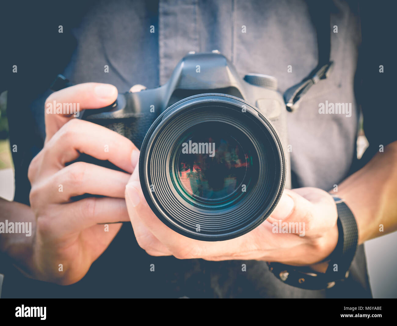 Photographer holding DSLR camera Stock Photo - Alamy