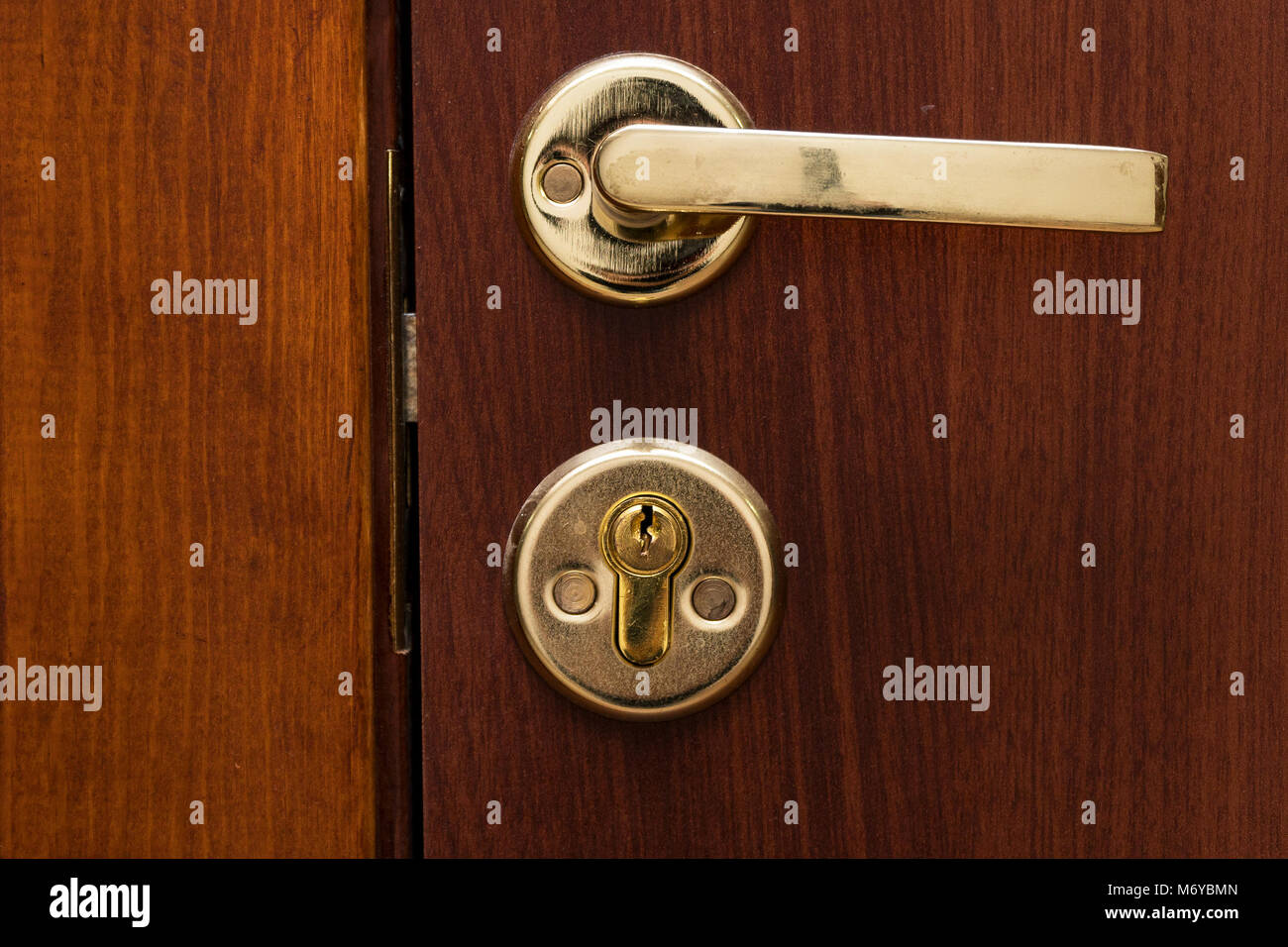 Door handle gold color with a lock Stock Photo - Alamy