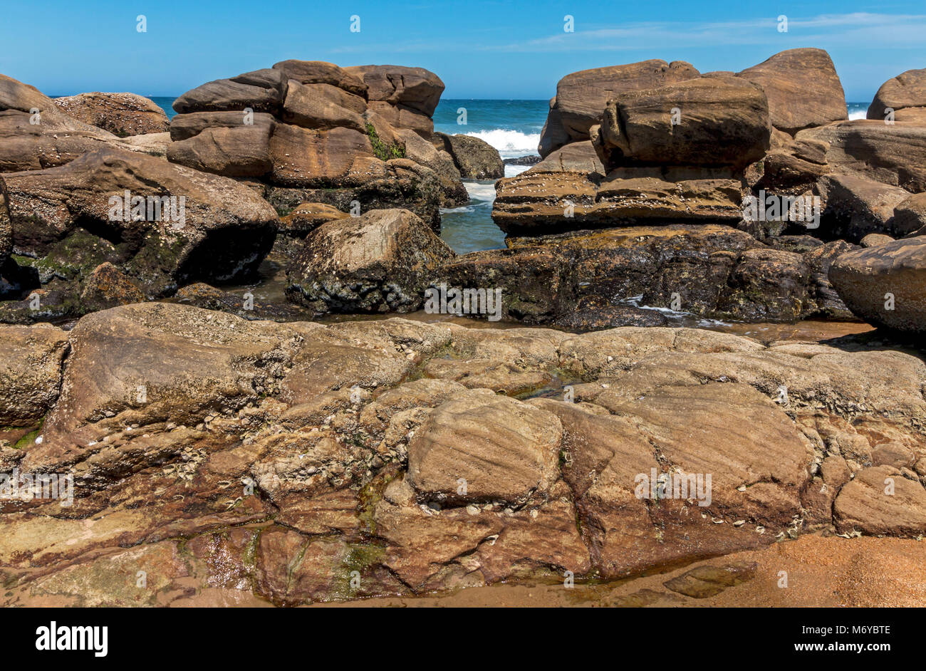 Close up of patterns and textures on large rocks on beach ocean with ...