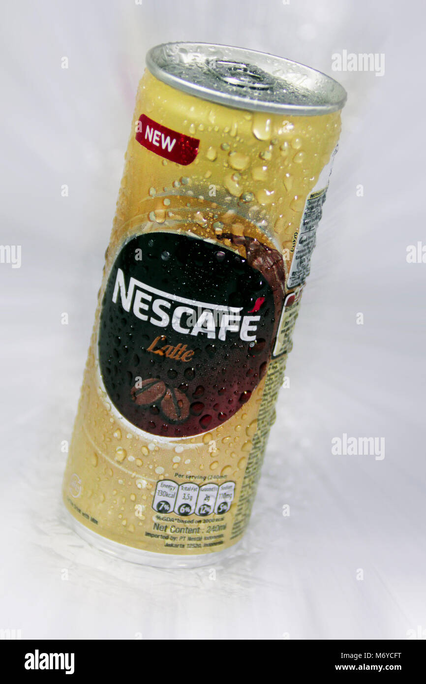 One can of nescafe coffee, white background with water grains, vertical ...