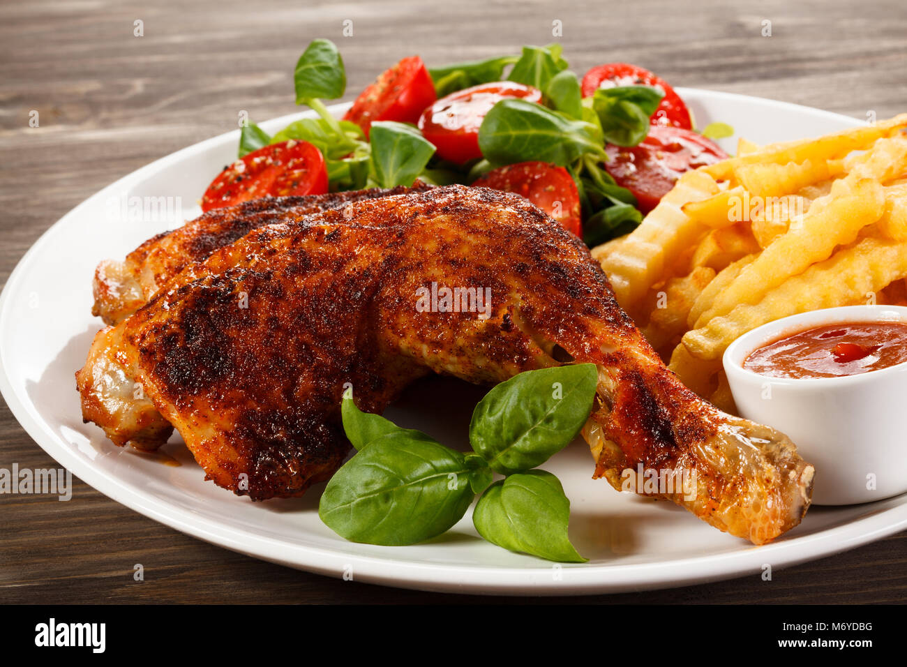 Roast chicken legs with french fries Stock Photo - Alamy