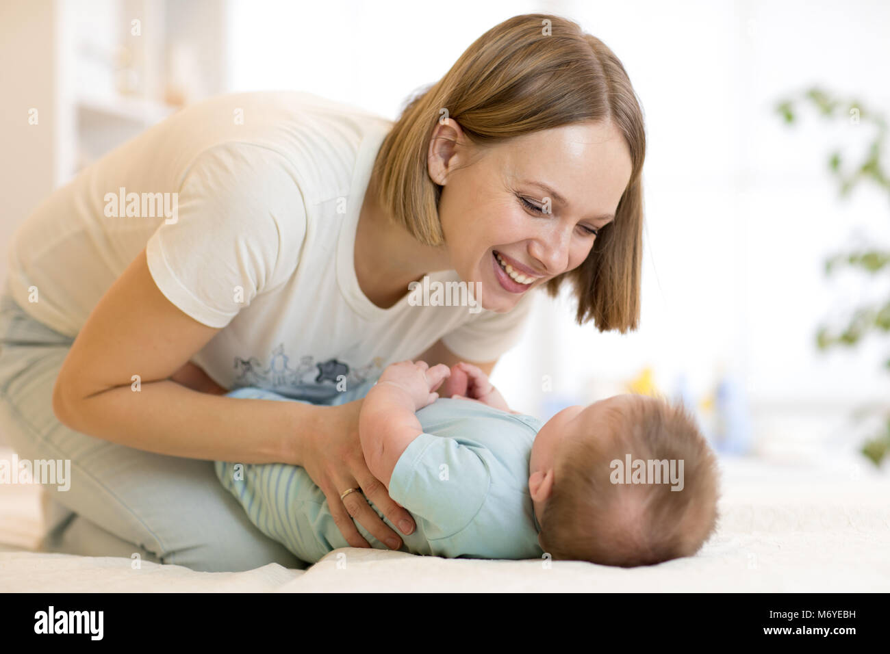 Pretty young woman looking after newborn baby Stock Photo - Alamy