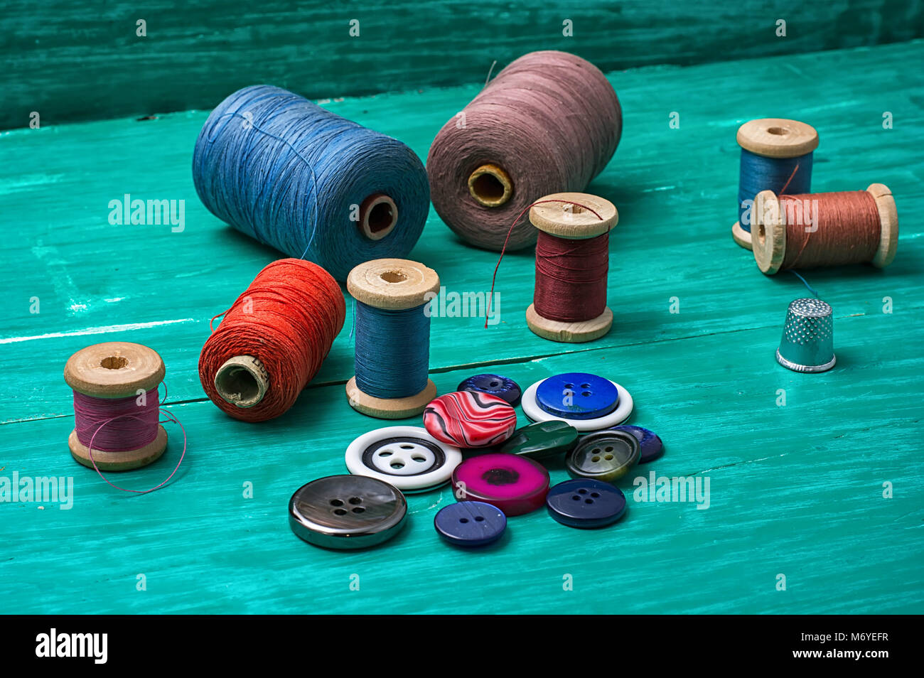 thread buttons for crafts on turquoise wooden background.Selective ...