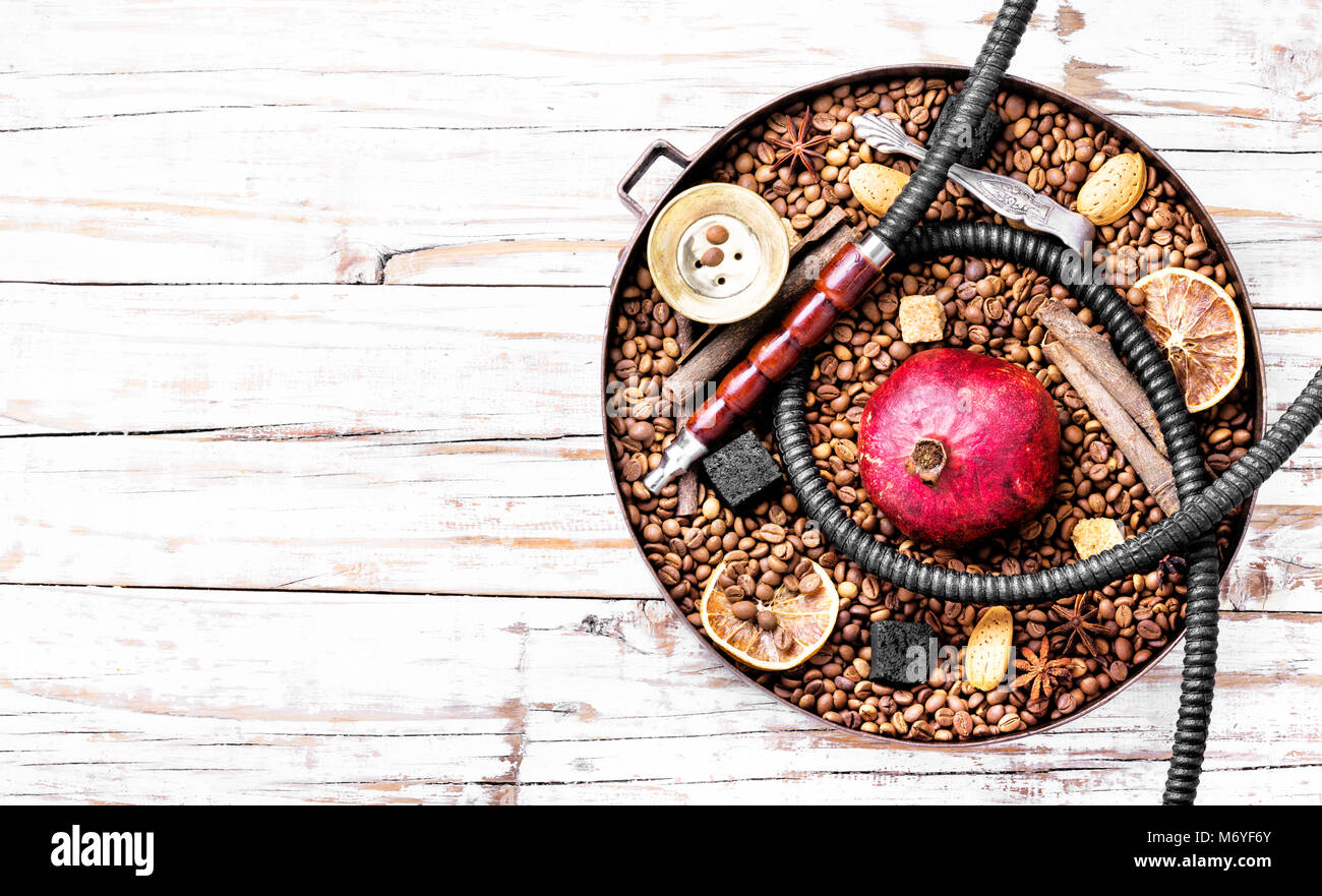 Smoke hookah with with coffee beans and pomegranate.Shisha concept ...