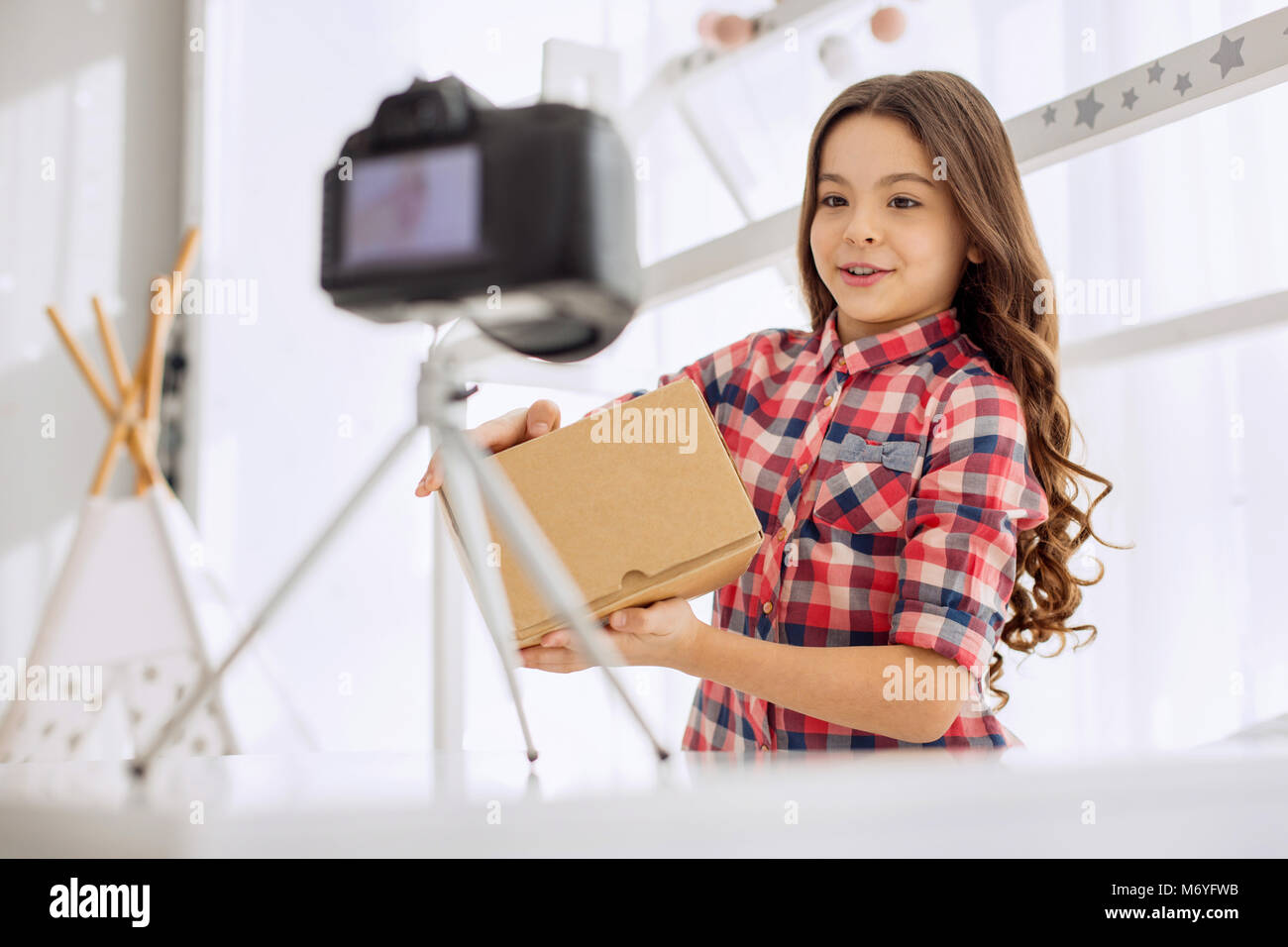 Upbeat girl presenting box in her unboxing video Stock Photo - Alamy