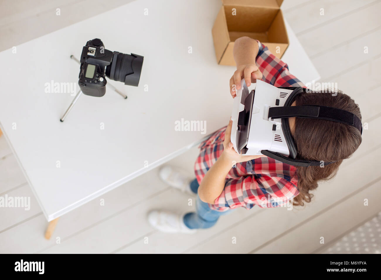 Pre-teen girl showing how to use VR headset correctly Stock Photo - Alamy