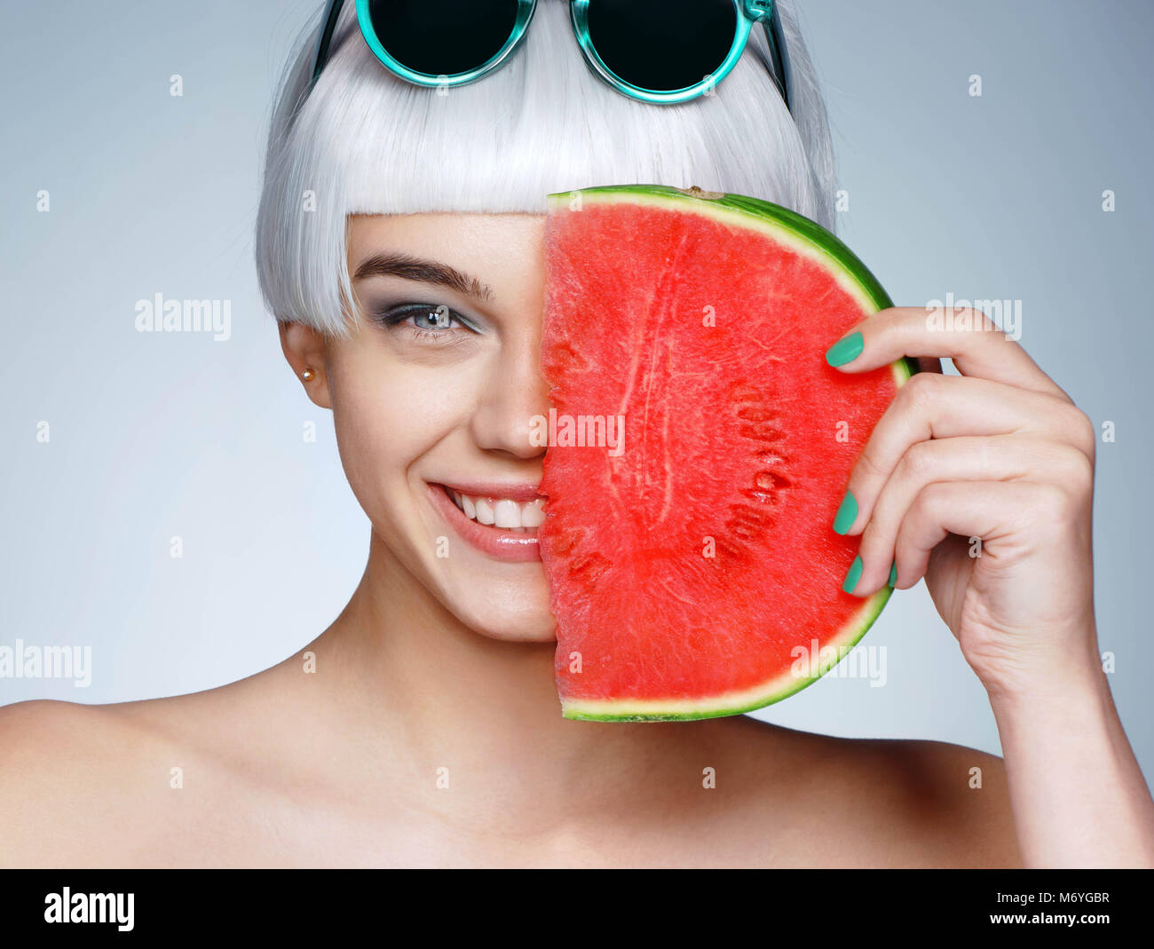 Lovely girl holding red ripe watermelon slice near her face. Photo of ...
