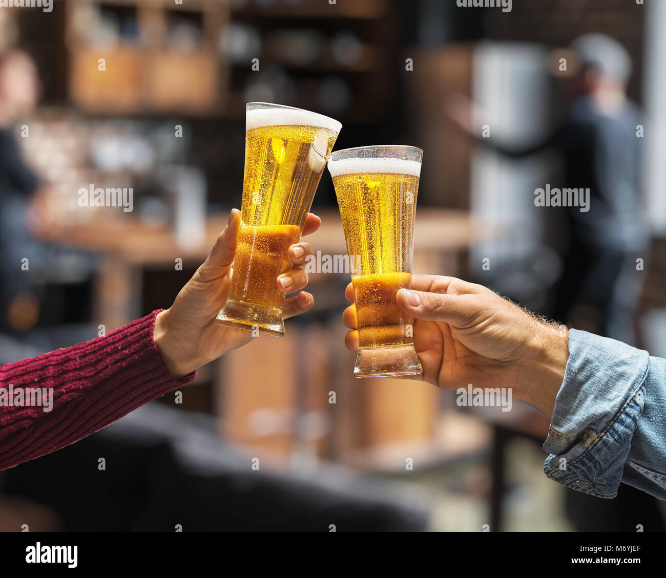 Beer glasses raised in a toast. Close-up hands with glasses. Blurred ...