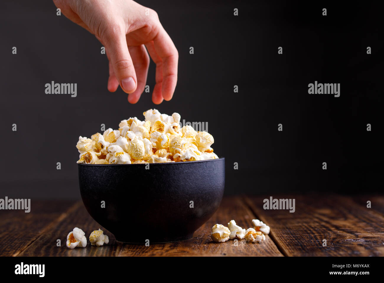 The hand that stretches behind the mouth-watering popcorn. Still-life ...