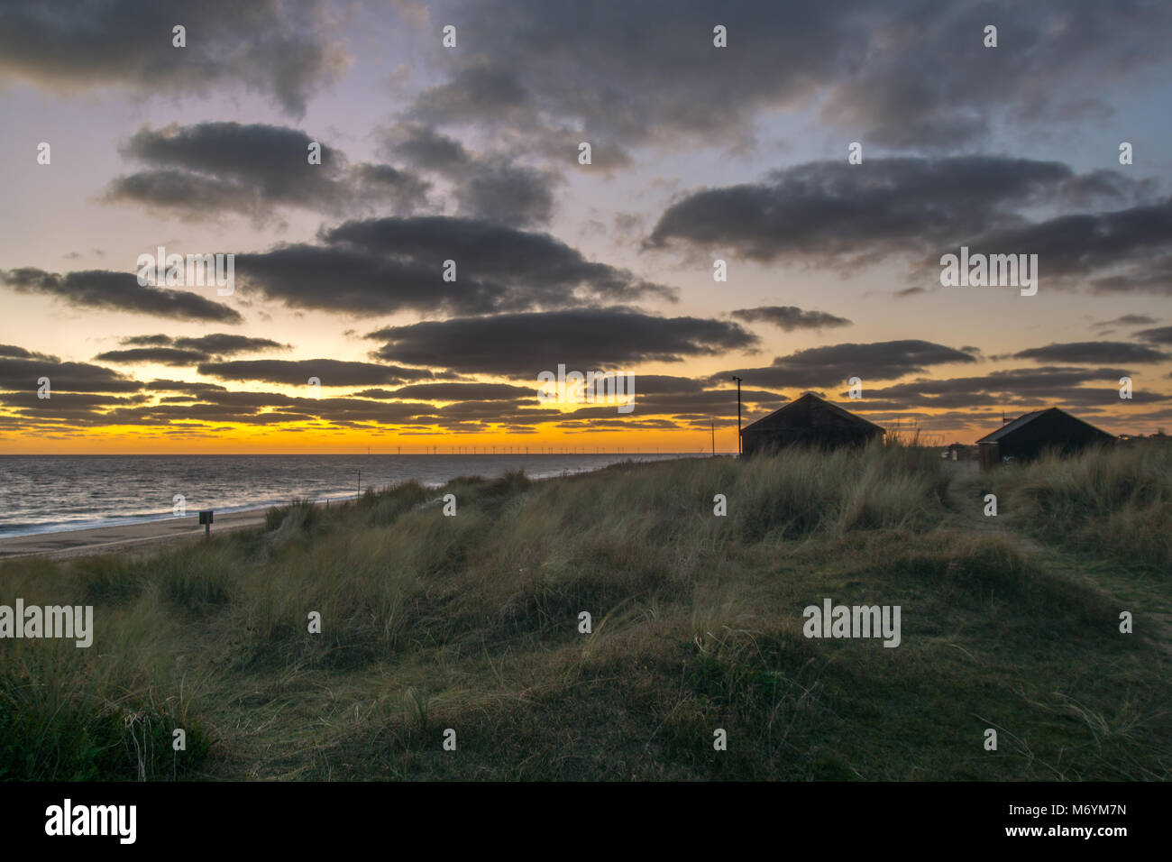 Beach huts at winterton on sea pictured through the rolling sand dunes ...