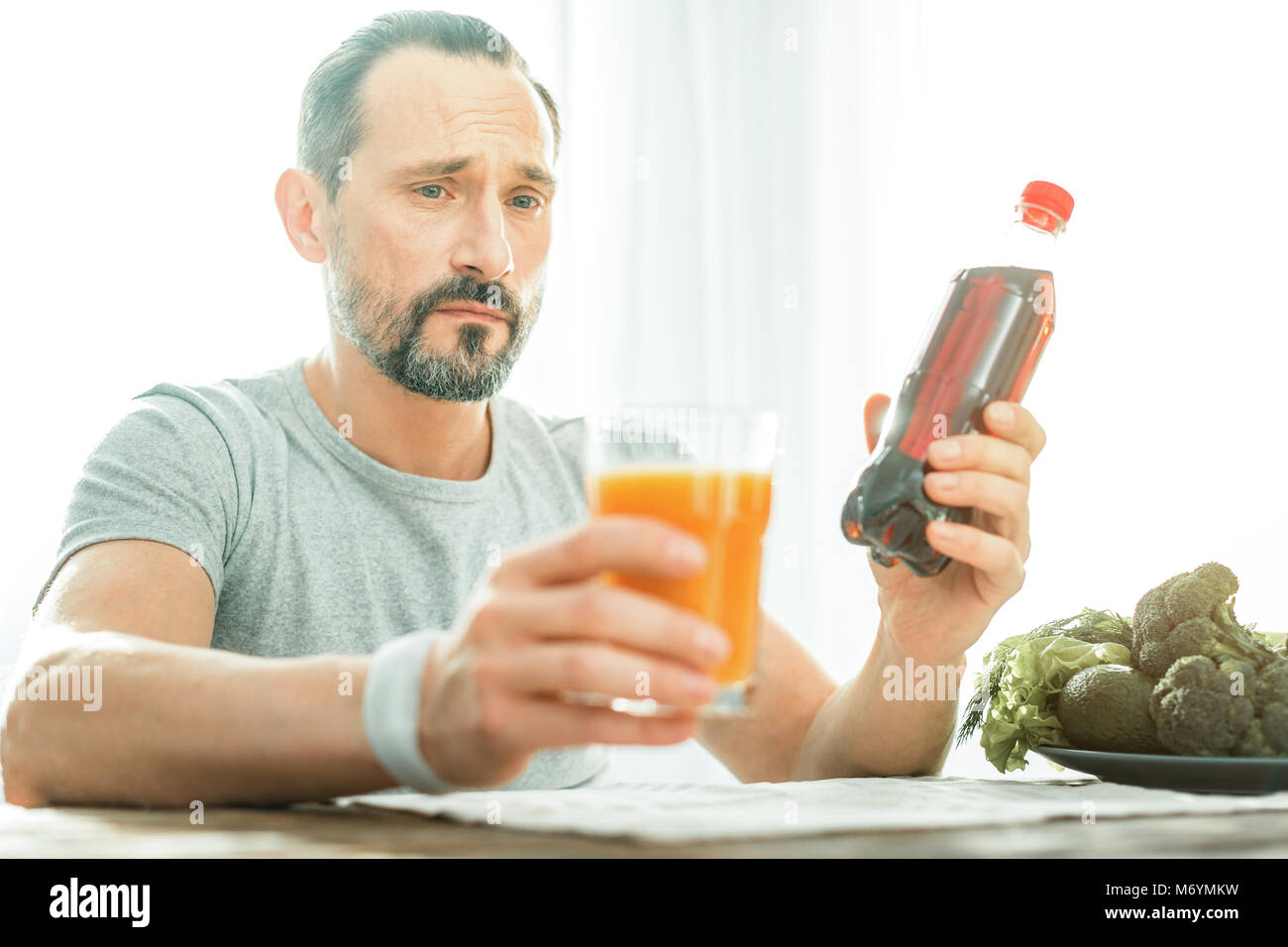 Confused thoughtful man sitting and overlooking drinks Stock Photo - Alamy