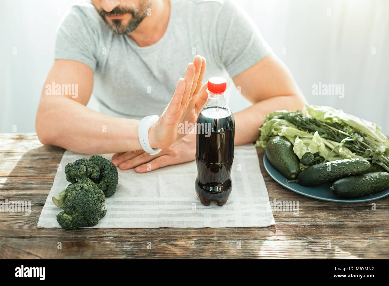 Unshaken concentrated man gesticulating and sitting by the table Stock ...