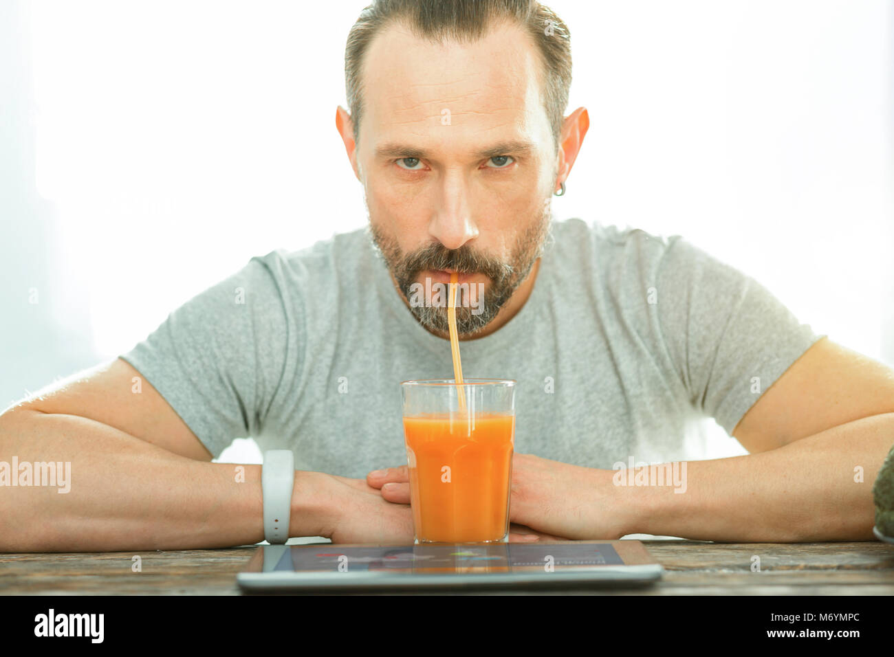 Serious unhappy man sitting and drinking juice Stock Photo - Alamy