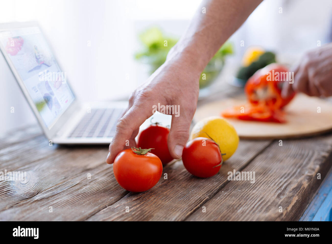 Handsome male hand taking tomato Stock Photo - Alamy