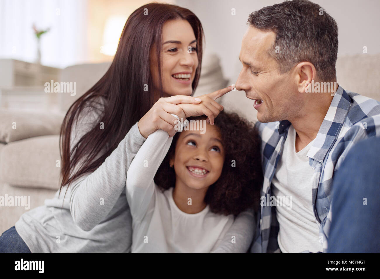 Alert mother and daughter playing with their father Stock Photo - Alamy