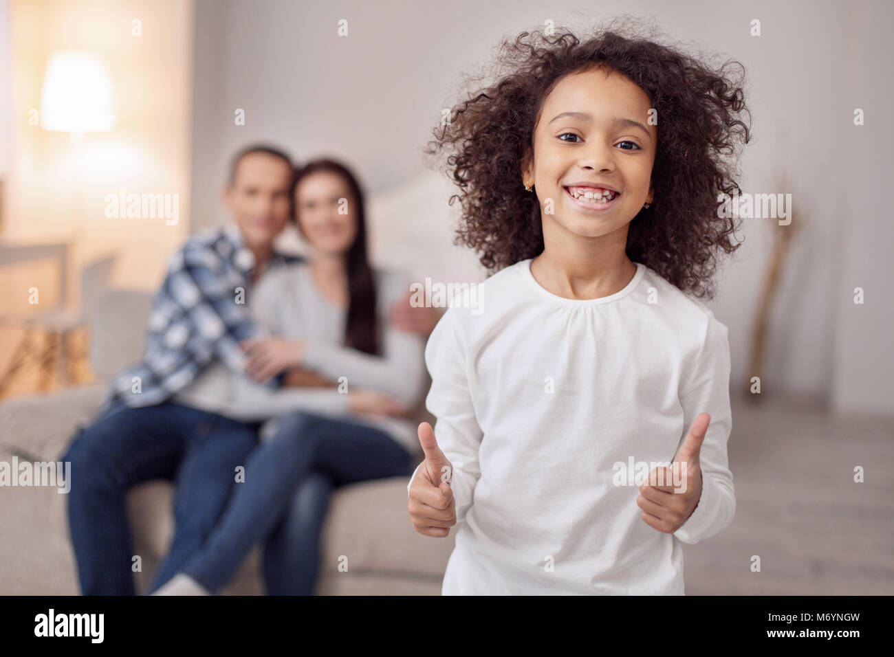 Inspired child showing her thumbs up Stock Photo - Alamy
