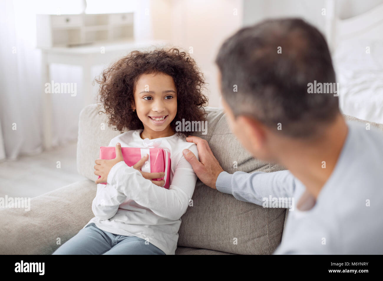 Alert girl holding her birthday gift Stock Photo - Alamy