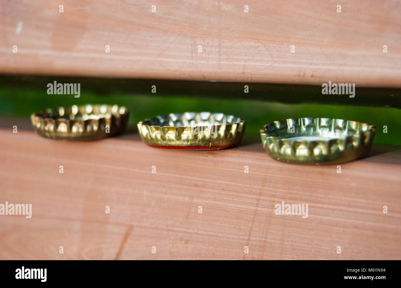 Three stacked bottle caps side by side on a bench Stock Photo - Alamy