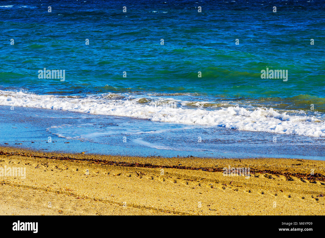 close up of the sea water affecting the sand on the beach, sea waves ...