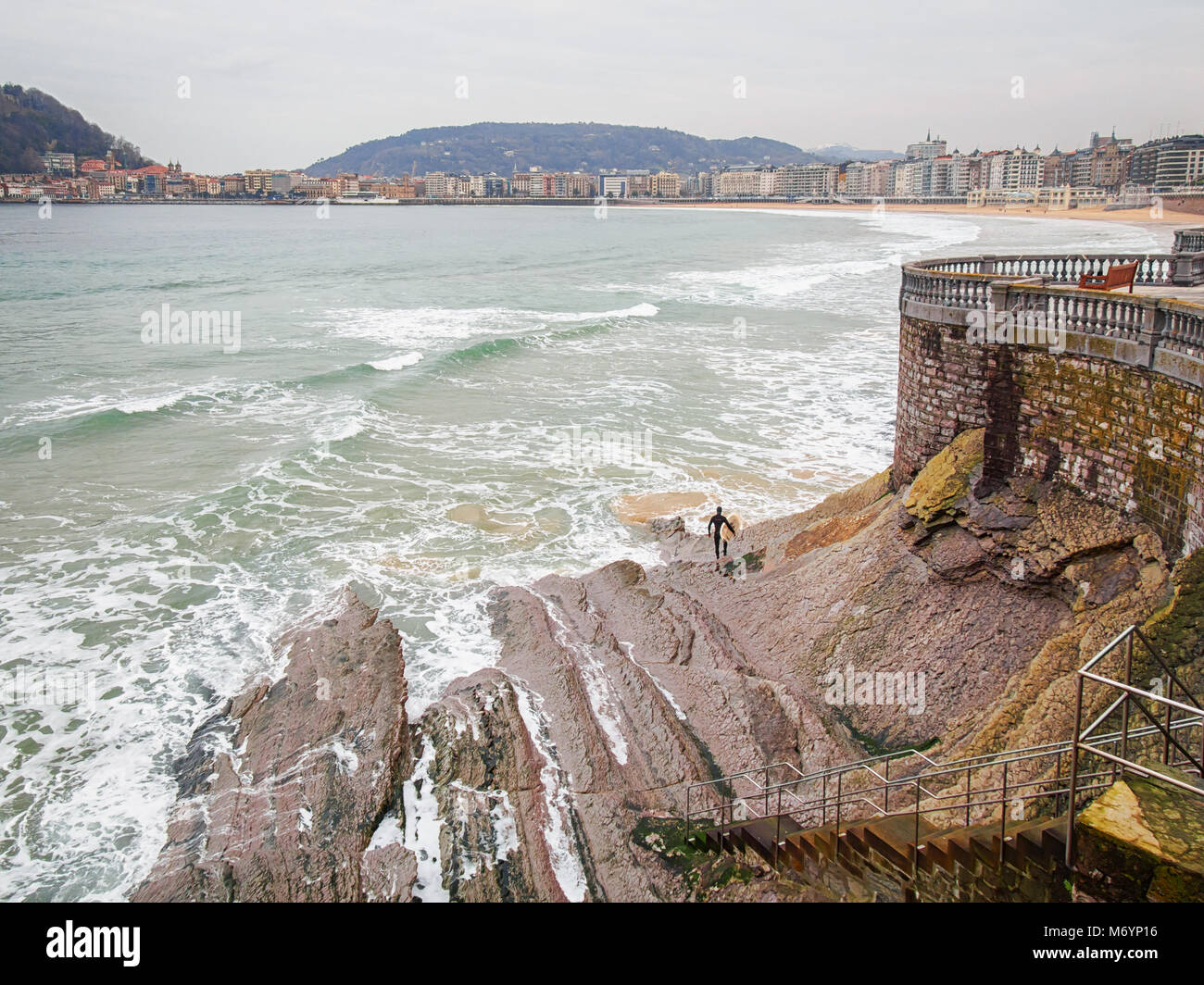 Man with his board is getting ready for surfing on the flysh cliff at ...