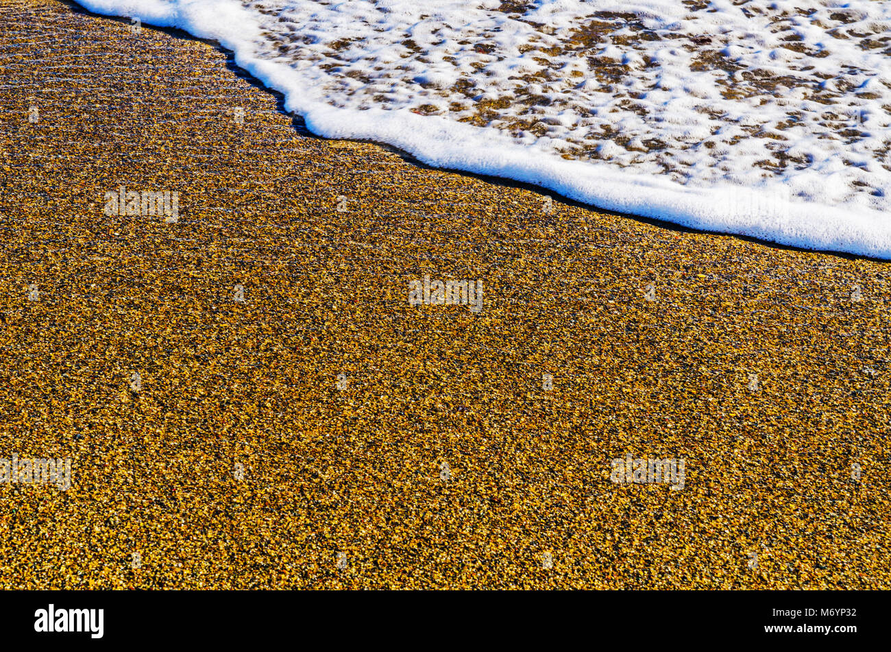 close up of the sea water affecting the sand on the beach, sea waves ...