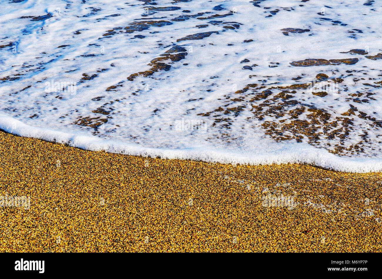 close up of the sea water affecting the sand on the beach, sea waves ...