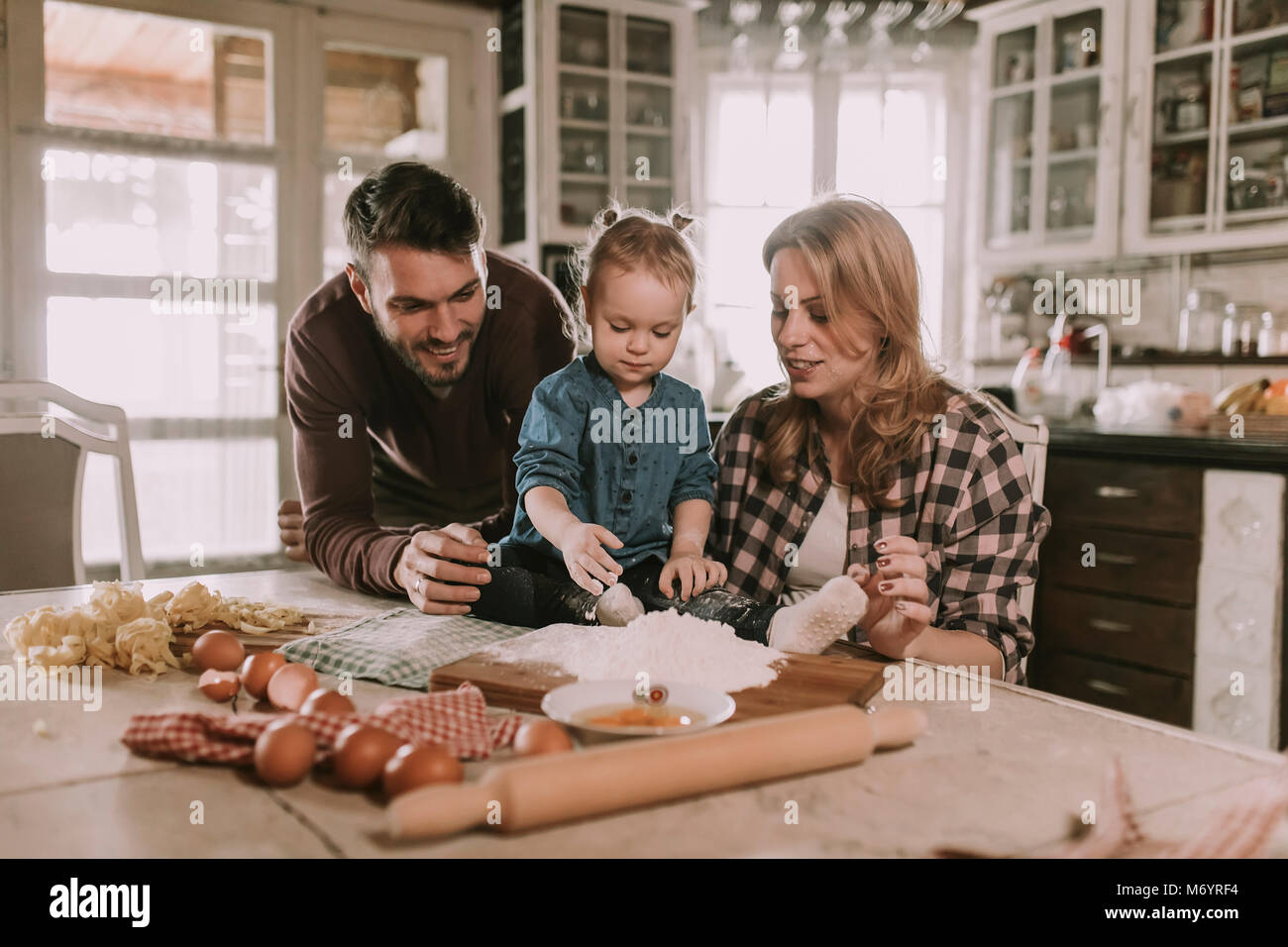 Happy family making pasta in the kitchen at home Stock Photo - Alamy