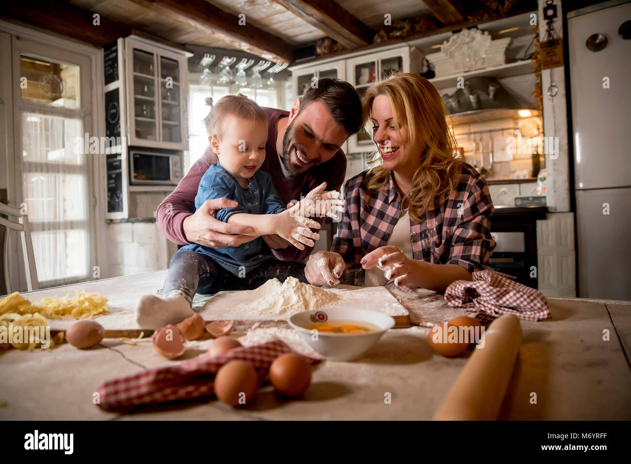 Happy family making pasta in the kitchen at home Stock Photo - Alamy